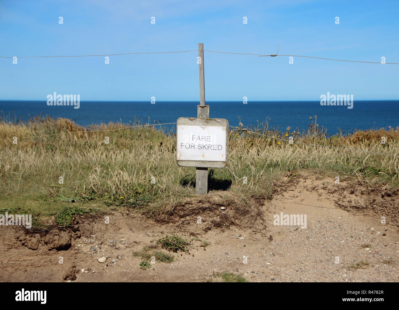 Danish Sign at Edge of Cliff warning of Erosion Stock Photo - Alamy