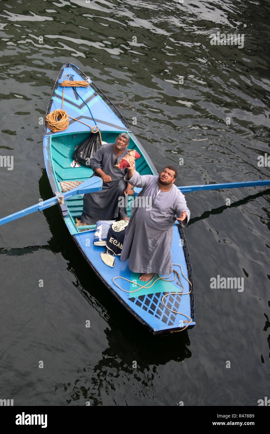 Egyptian men throw souvenir towels and cloths for sale from a boat to ...