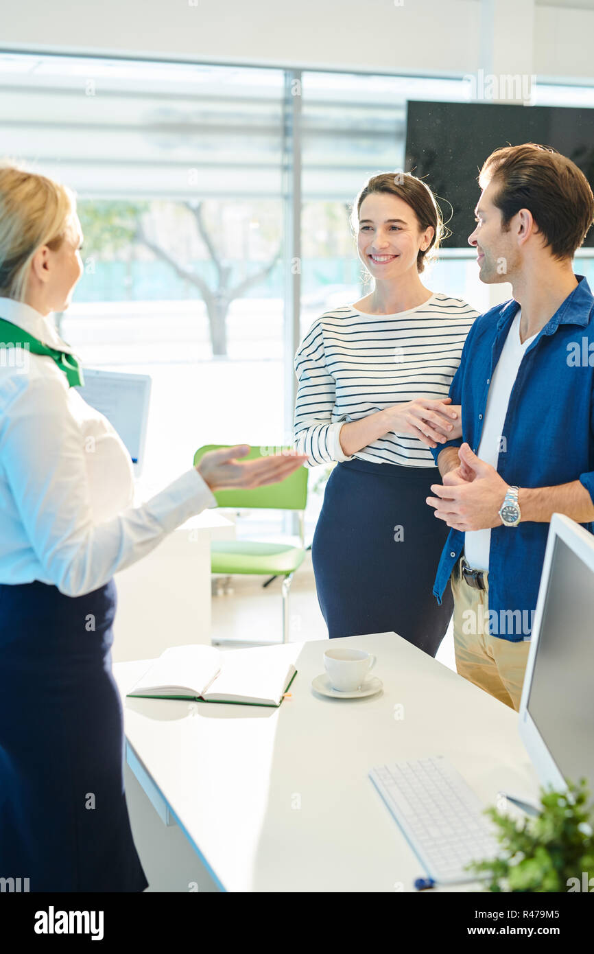 Bank representative welcoming young couple Stock Photo - Alamy