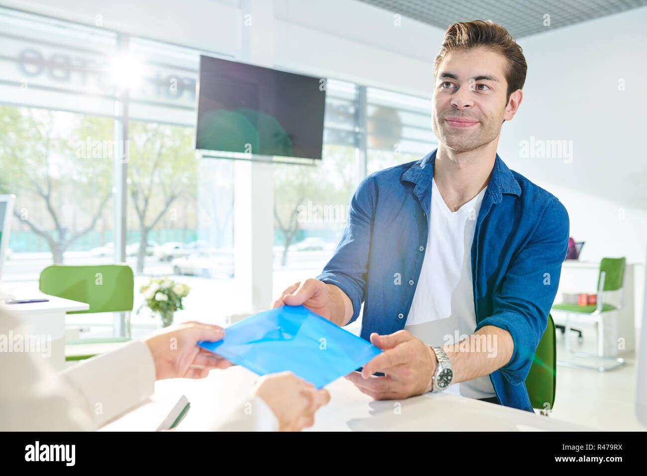 Content man taking folder with documents in bank Stock Photo - Alamy
