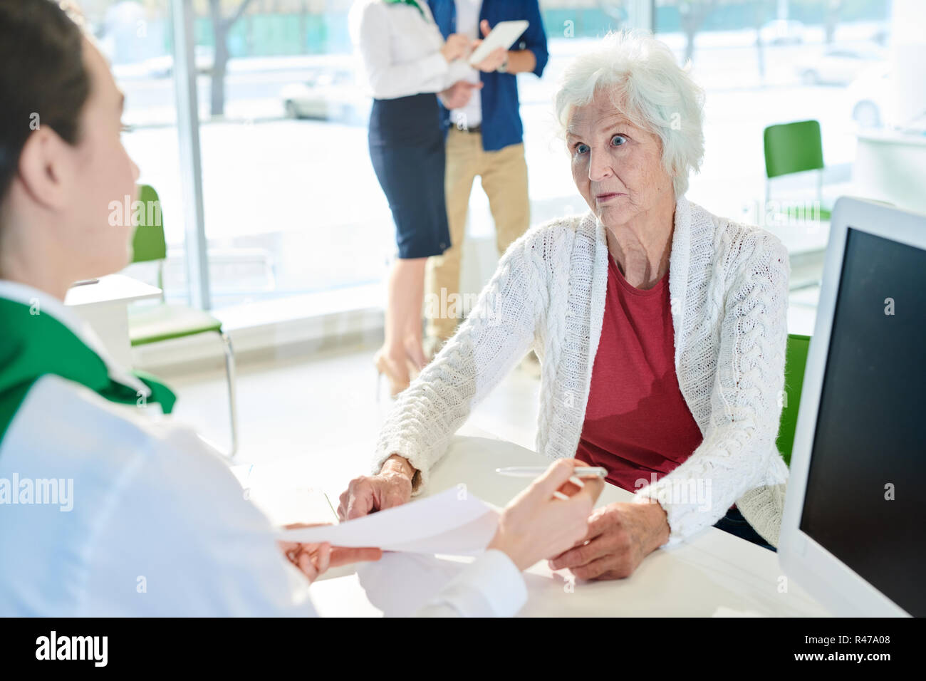 Shocked senior customer looking at bank specialist Stock Photo - Alamy