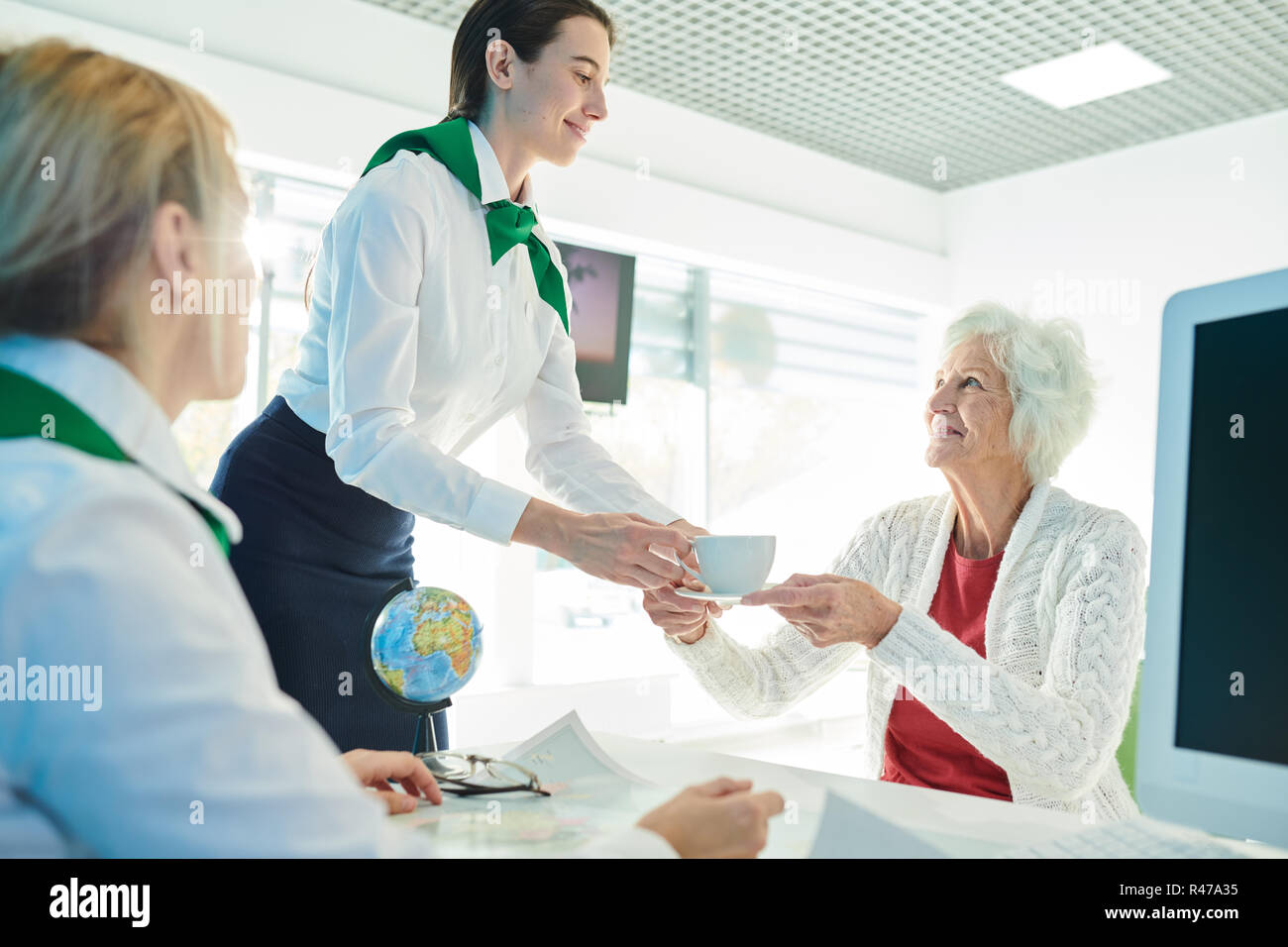 Taking care of client in travel agency office Stock Photo - Alamy