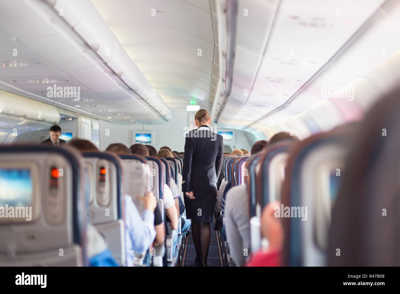 Stewardess and passengers on commercial airplane Stock Photo - Alamy
