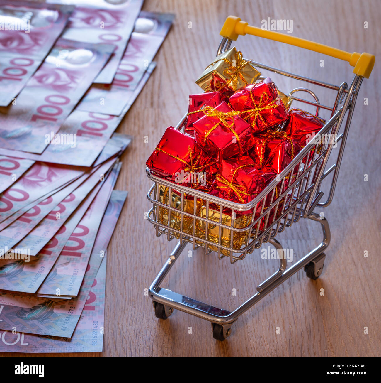 miniature shopping trolley with presents and New Zealand dollars as a ...