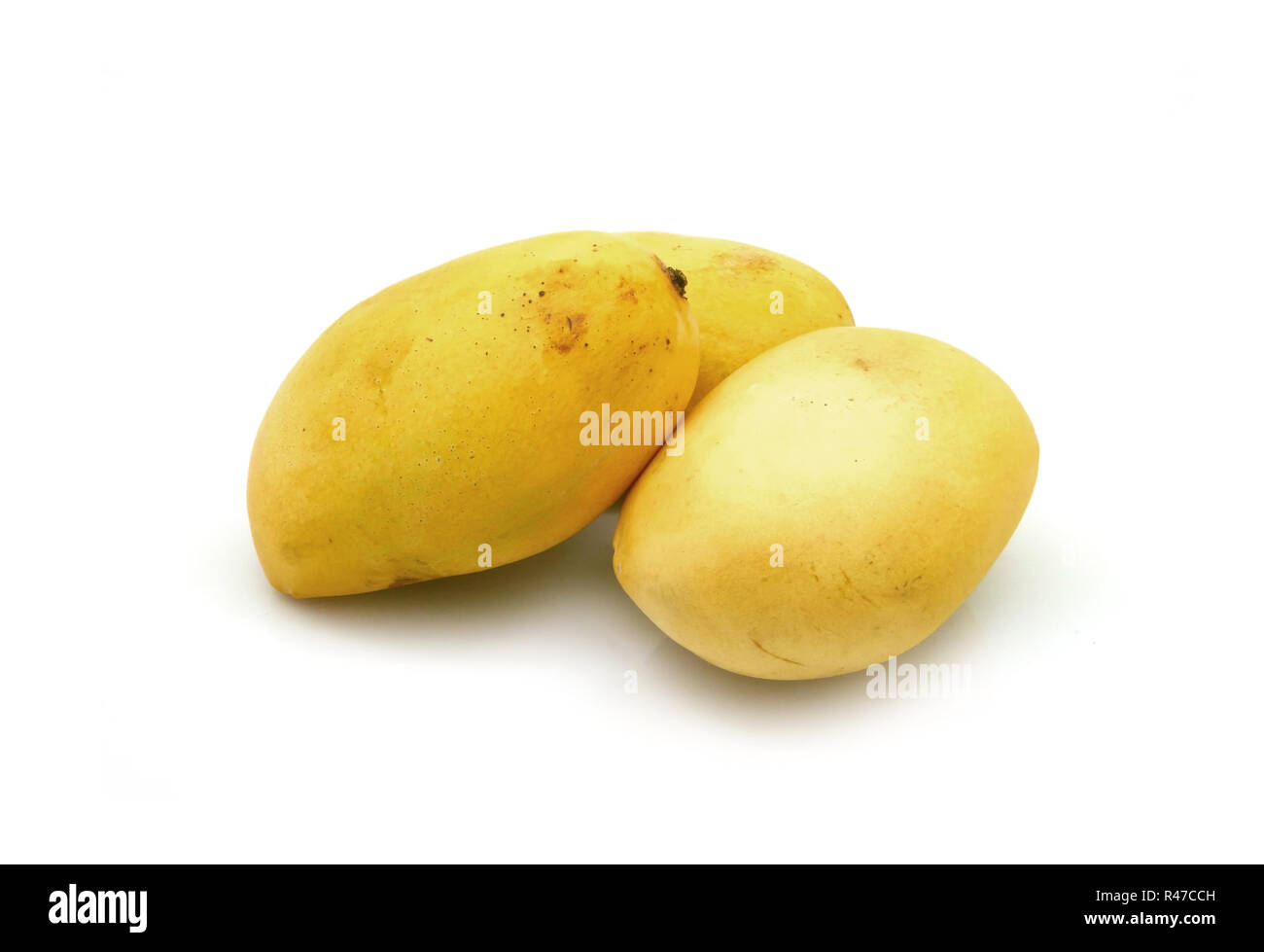 three yellow mangos Stock Photo - Alamy