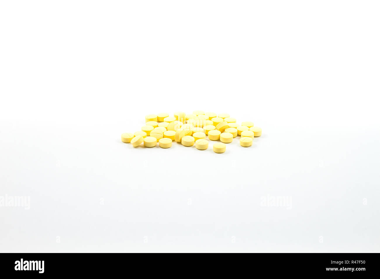 Yellow pills isolated on white background Stock Photo - Alamy