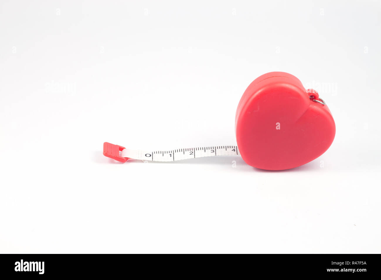 Measuring tape in heart shape on white background Stock Photo - Alamy