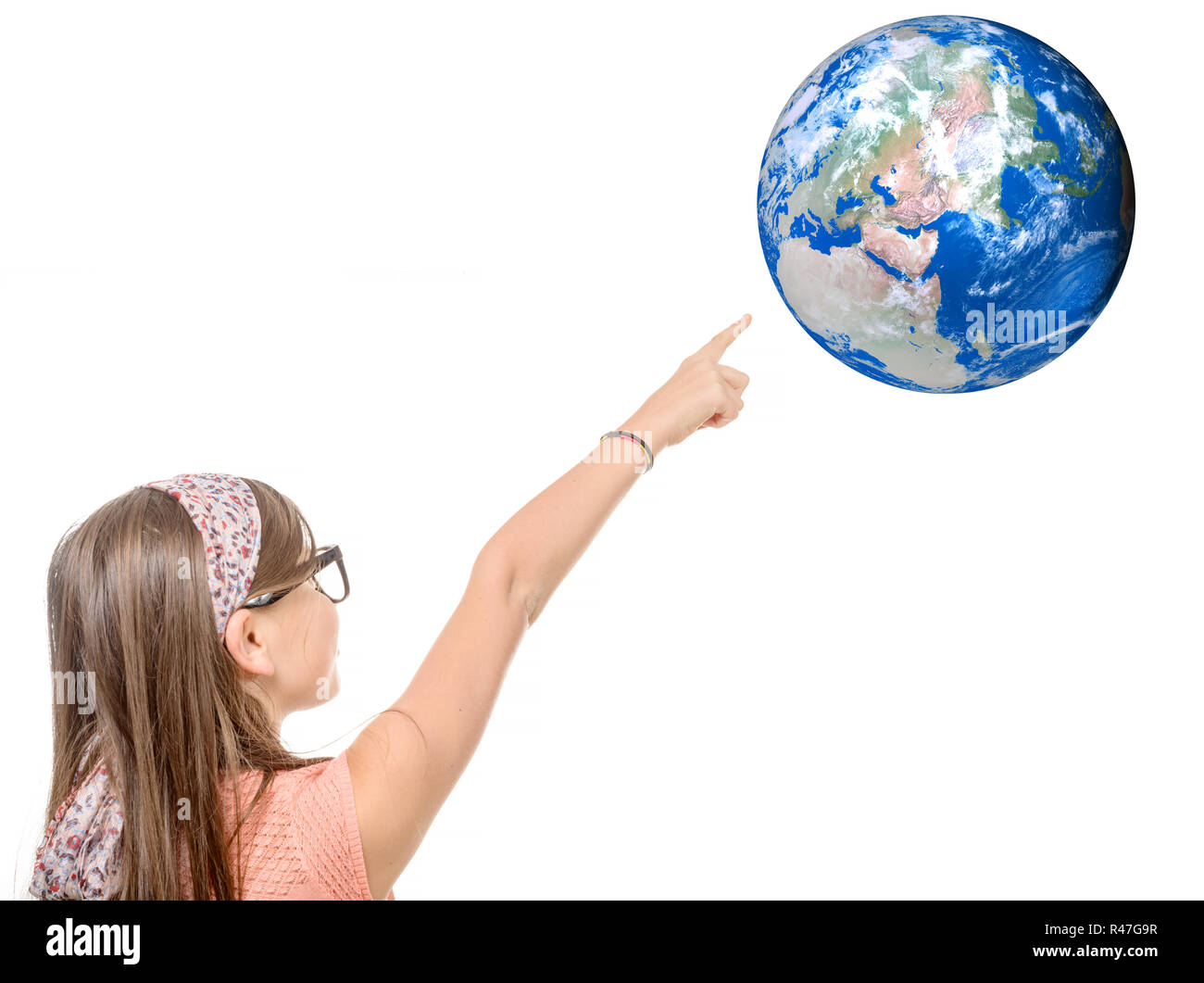 Portrait of a smiling little girl pointing finger on world globe on ...