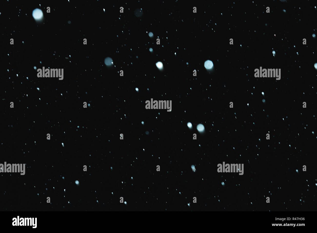 Flakes of snow falling on a black background. Isolated Stock Photo - Alamy