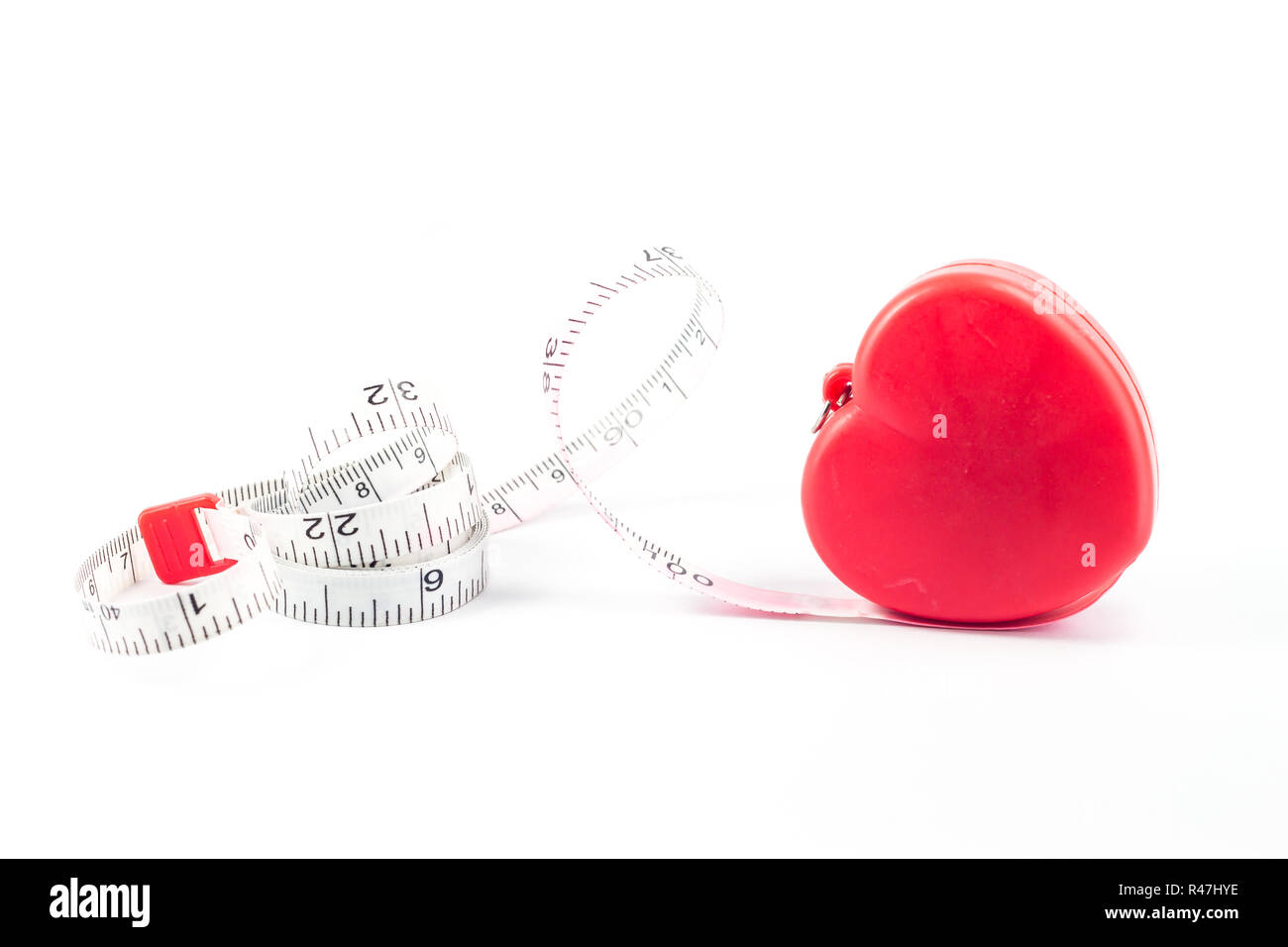 Measuring tape in heart shape on white background Stock Photo - Alamy