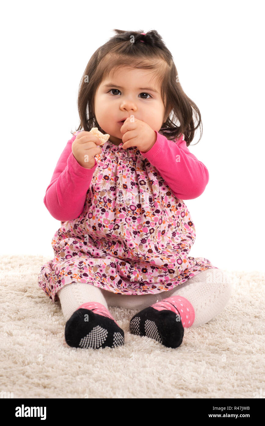 toddler in dress eating a biscuit Stock Photo - Alamy
