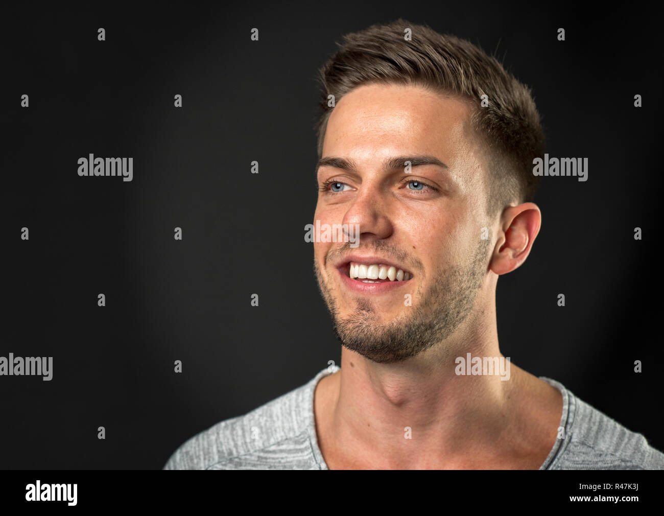 young man with three days beard in portrait smiling Stock Photo - Alamy