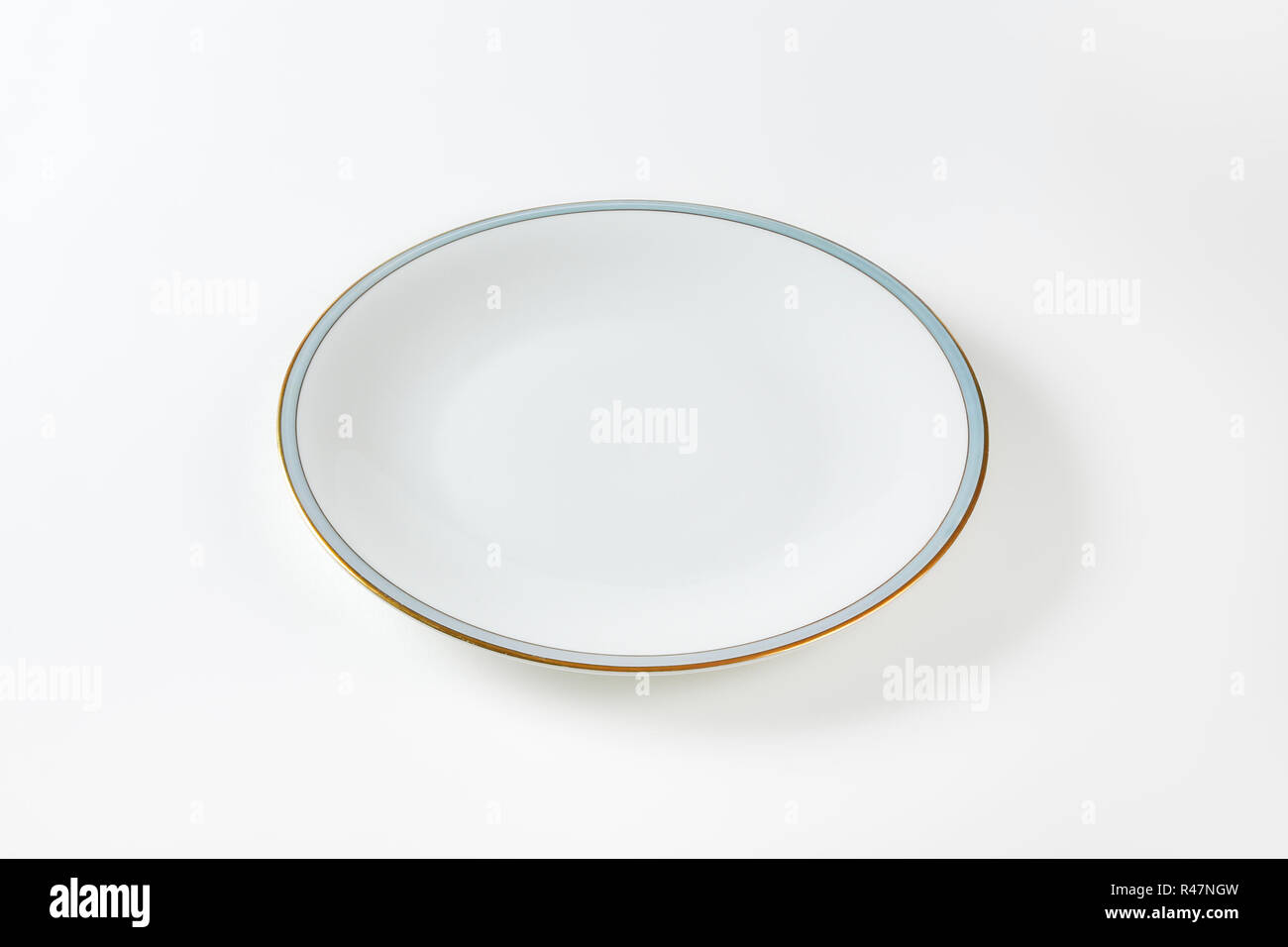 White plate with blue and gold band Stock Photo - Alamy