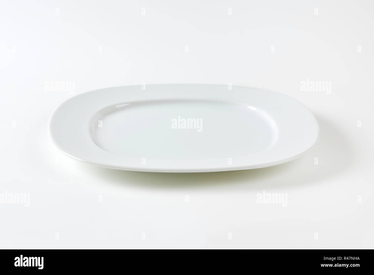 Wide rimmed square plate Stock Photo - Alamy