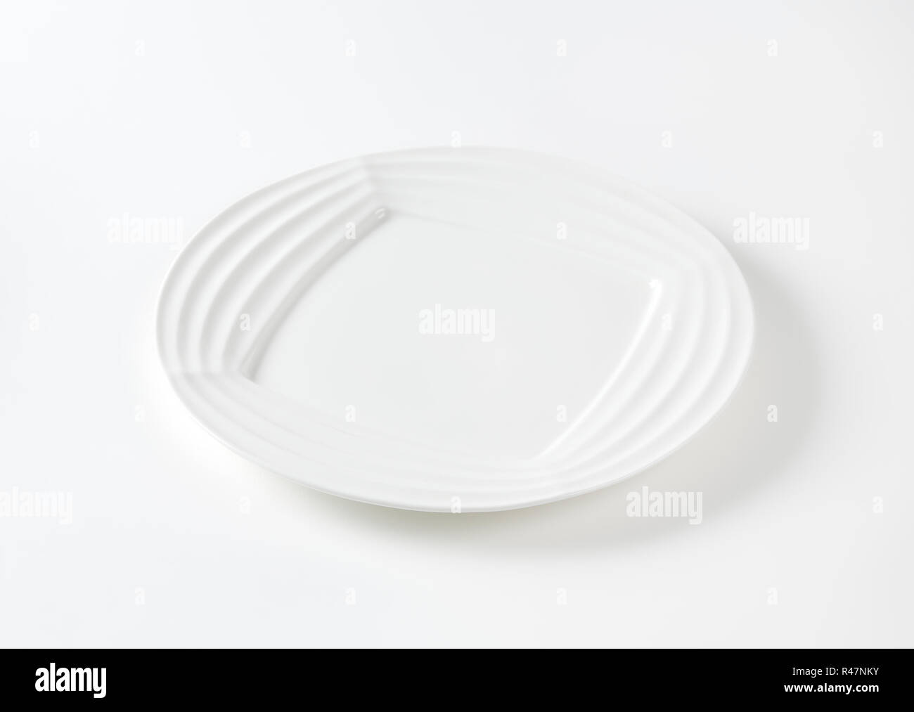 White dinner plate with ridged rim Stock Photo - Alamy