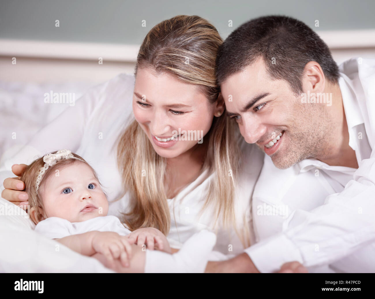Cute young family at home Stock Photo - Alamy