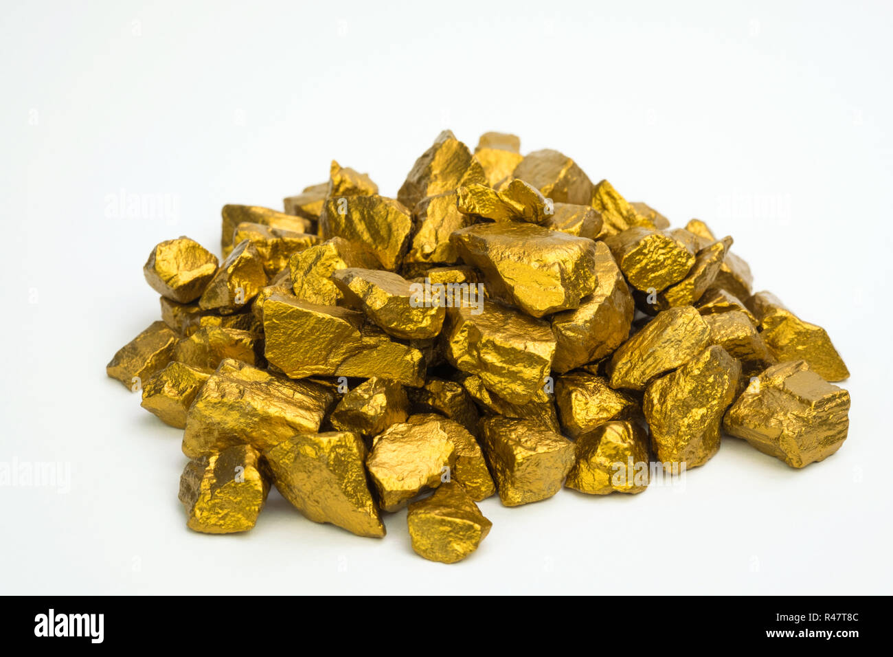 A pile of gold nuggets or gold ore isolated on white background ...