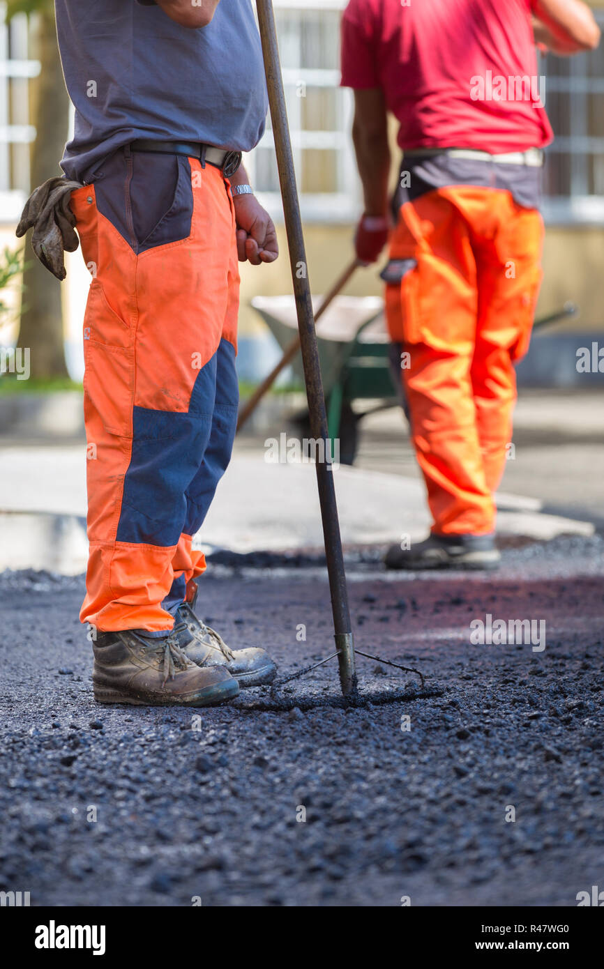 Asphalt surfacing manual labor Stock Photo - Alamy