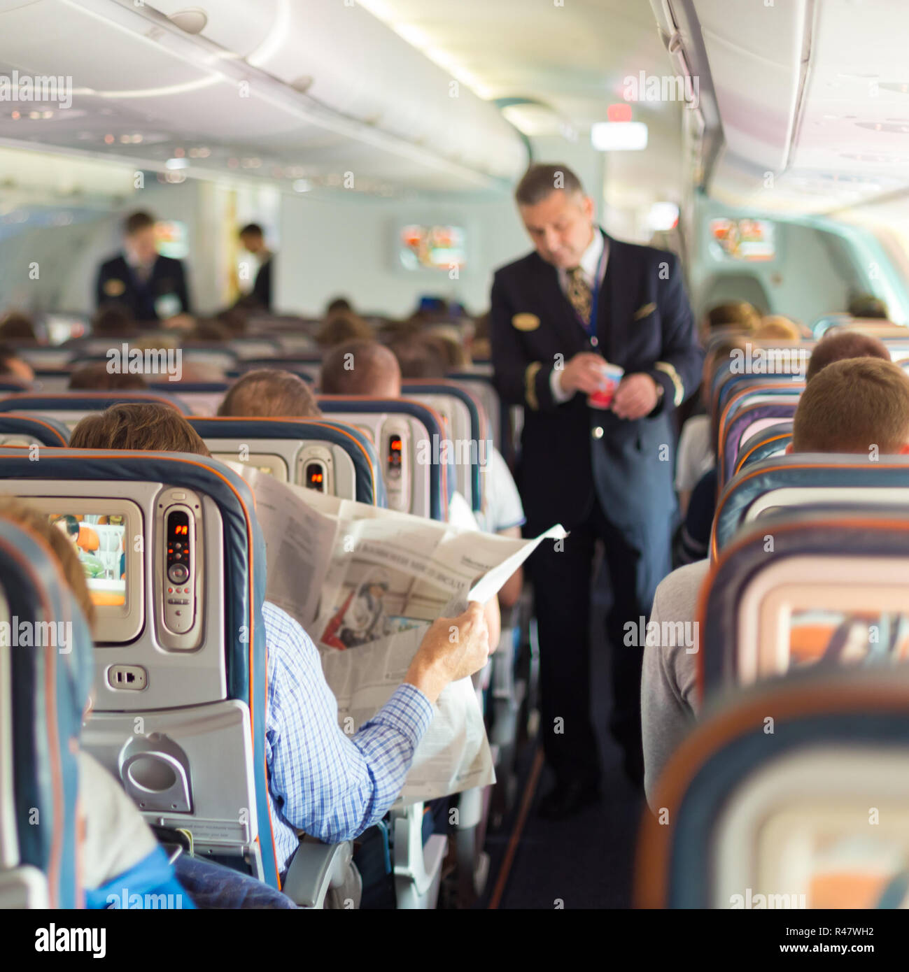 Steward and passengers on commercial airplane Stock Photo - Alamy
