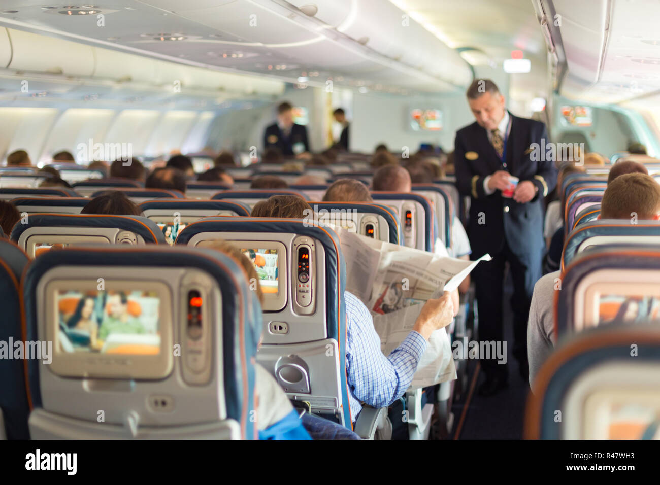 Steward and passengers on commercial airplane Stock Photo - Alamy
