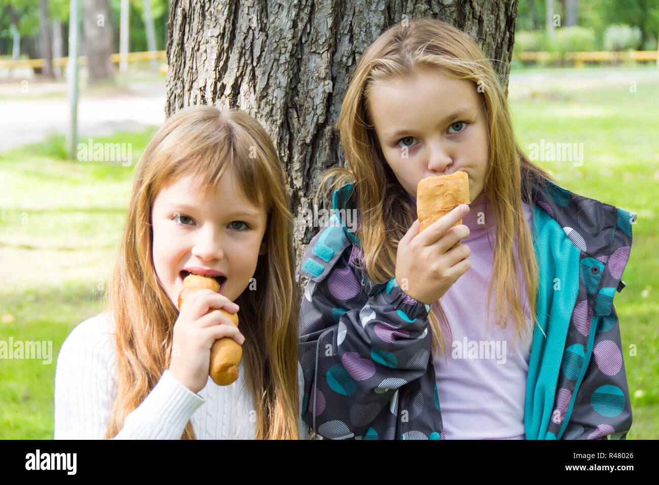 Cute two eating girls Stock Photo - Alamy
