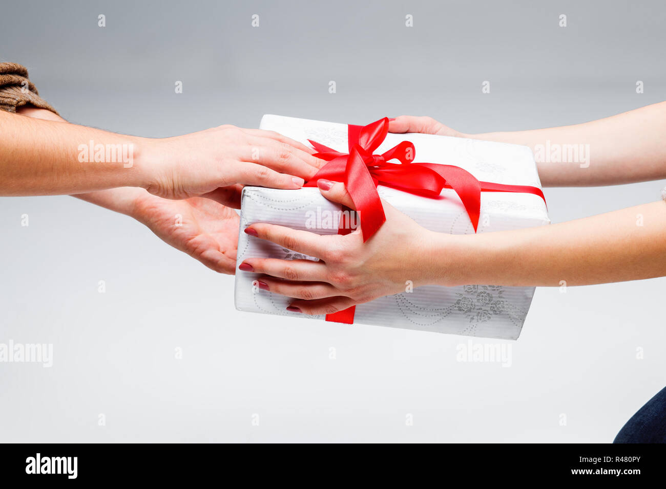 Hands giving and receiving a present Stock Photo - Alamy