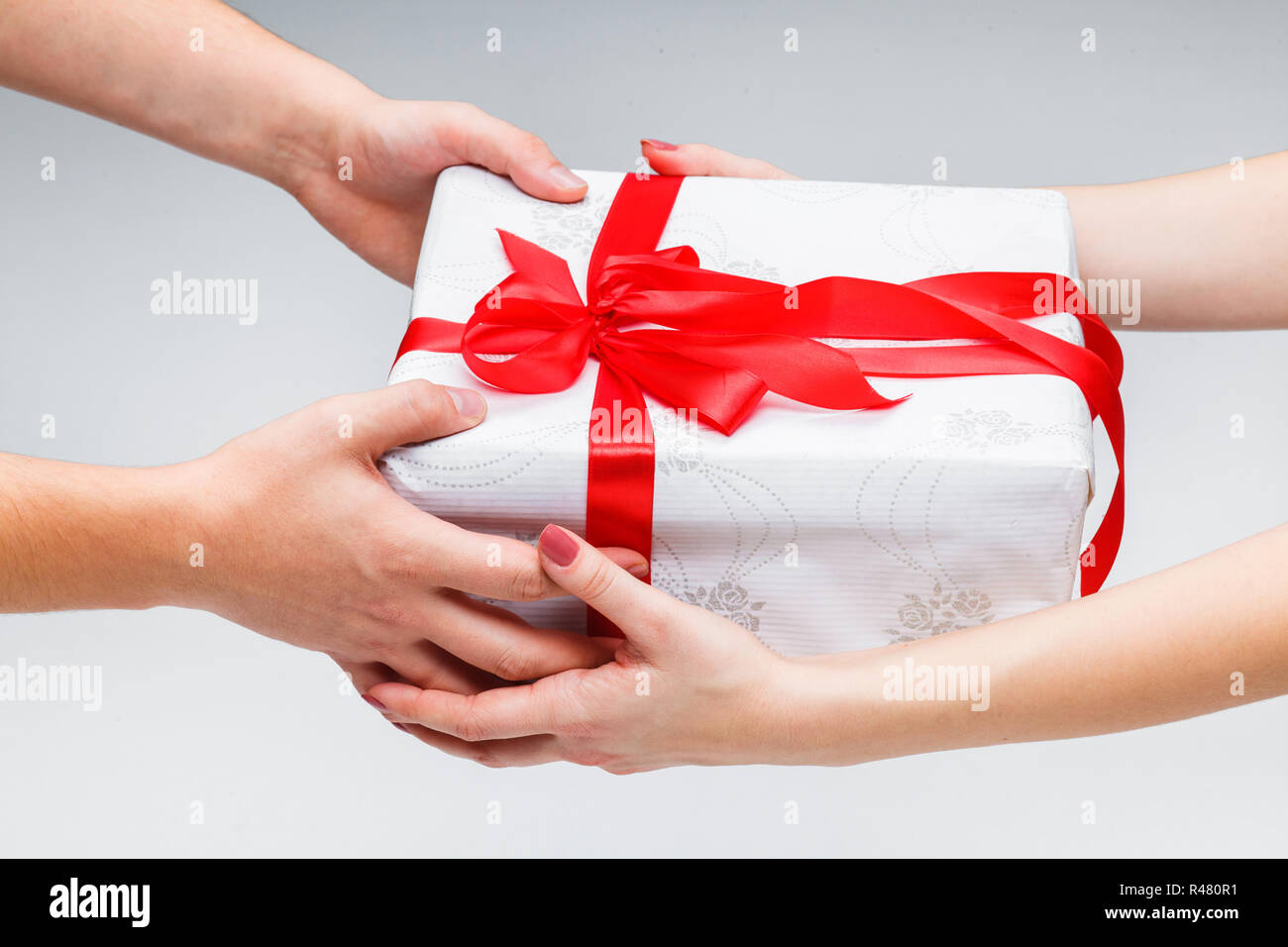 Hands giving and receiving a present Stock Photo - Alamy