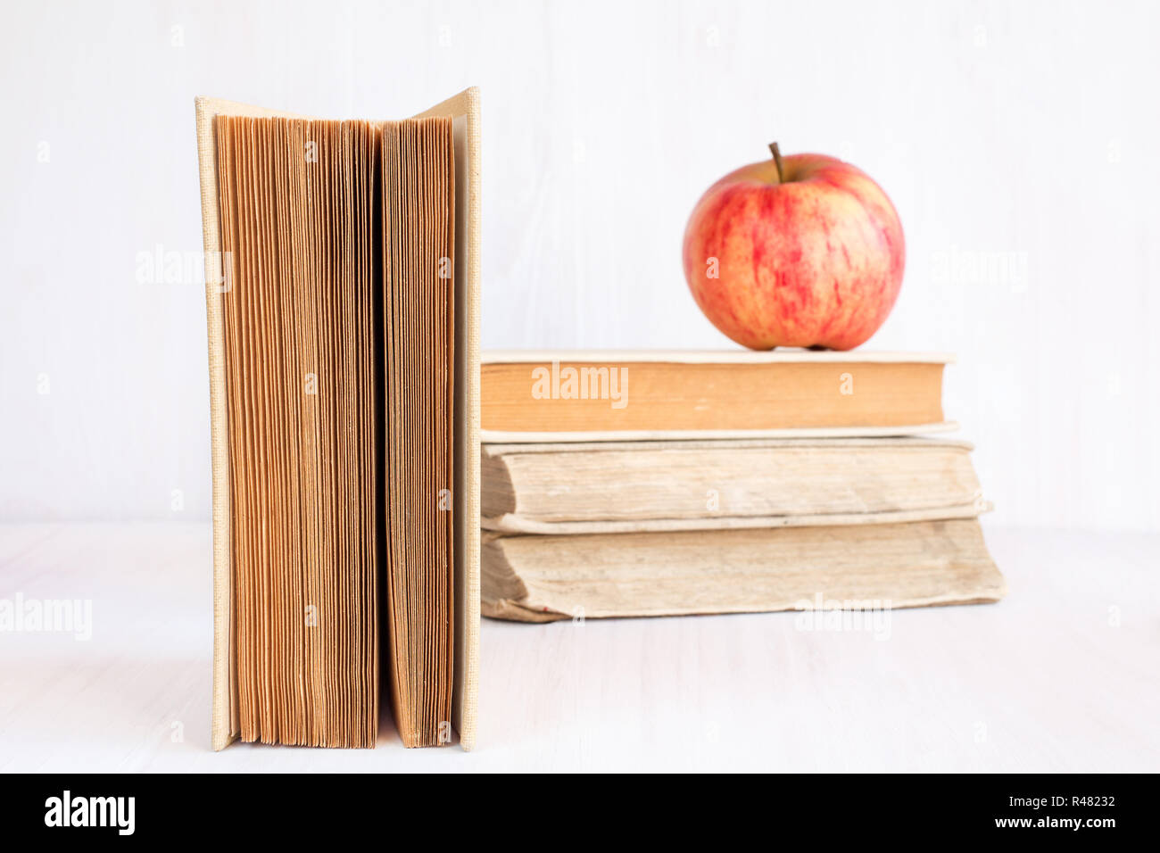 Books and apple on white bookshelf Stock Photo - Alamy