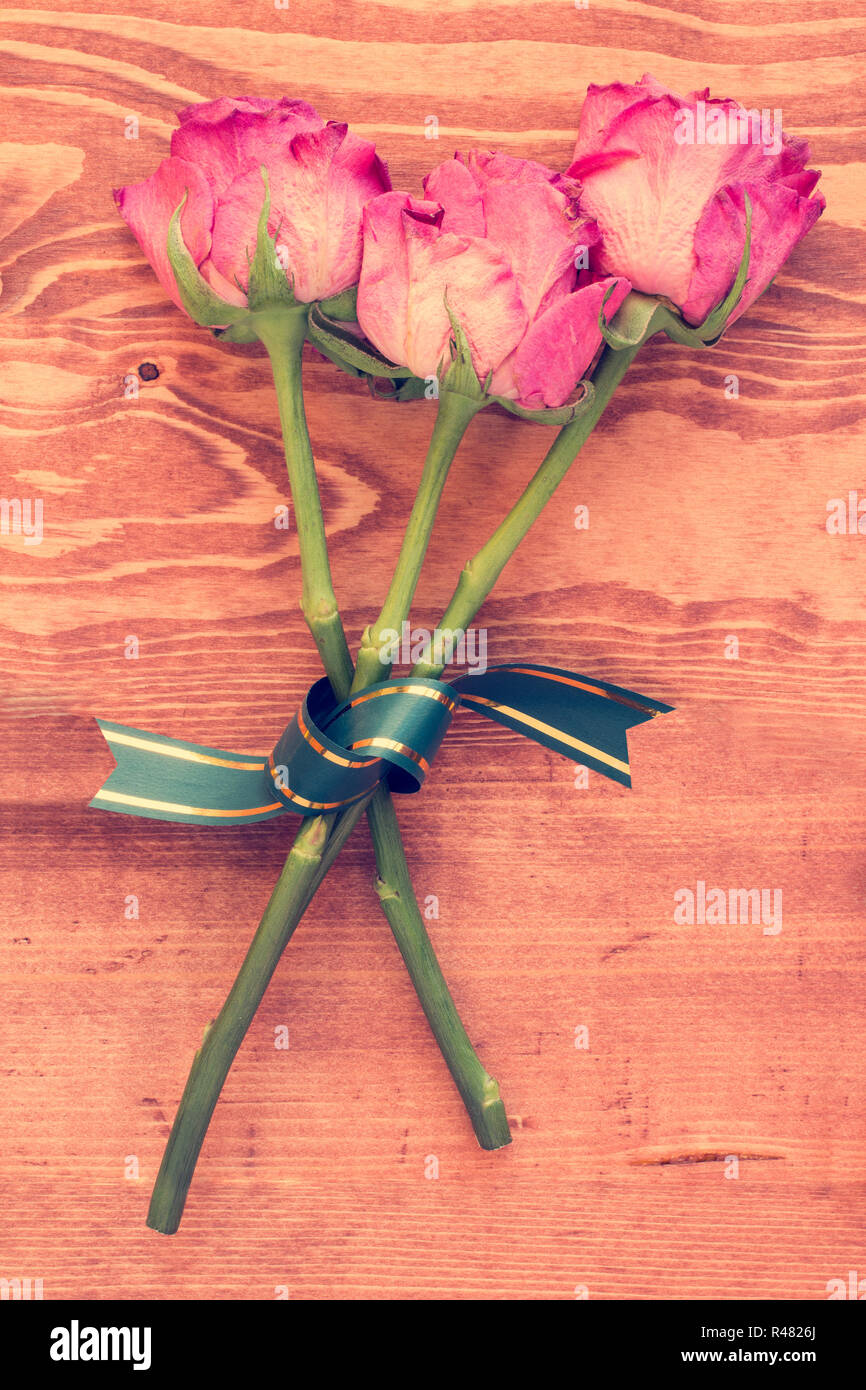 Three old roses with bow Stock Photo - Alamy