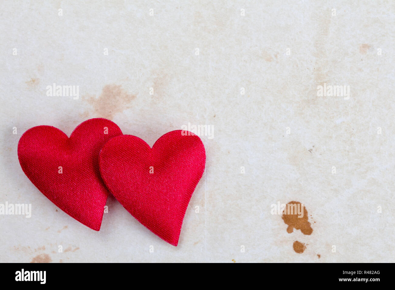 Two hearts on stained paper Stock Photo - Alamy