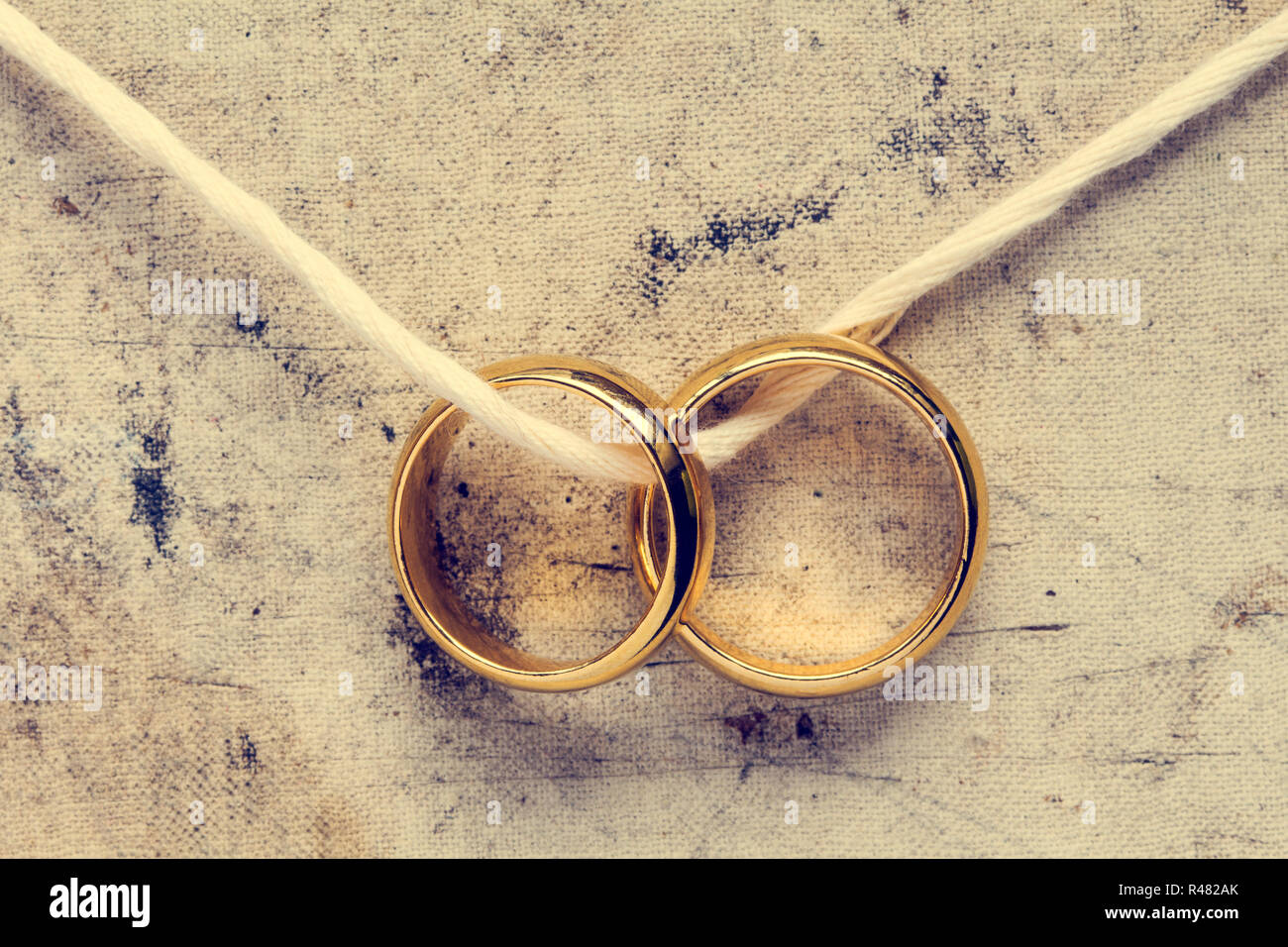 Wedding rings hanging on rope Stock Photo - Alamy