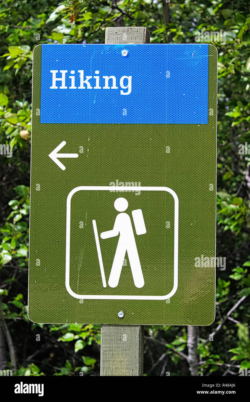 A blue and green hiking direction sign with an arrow Stock Photo - Alamy