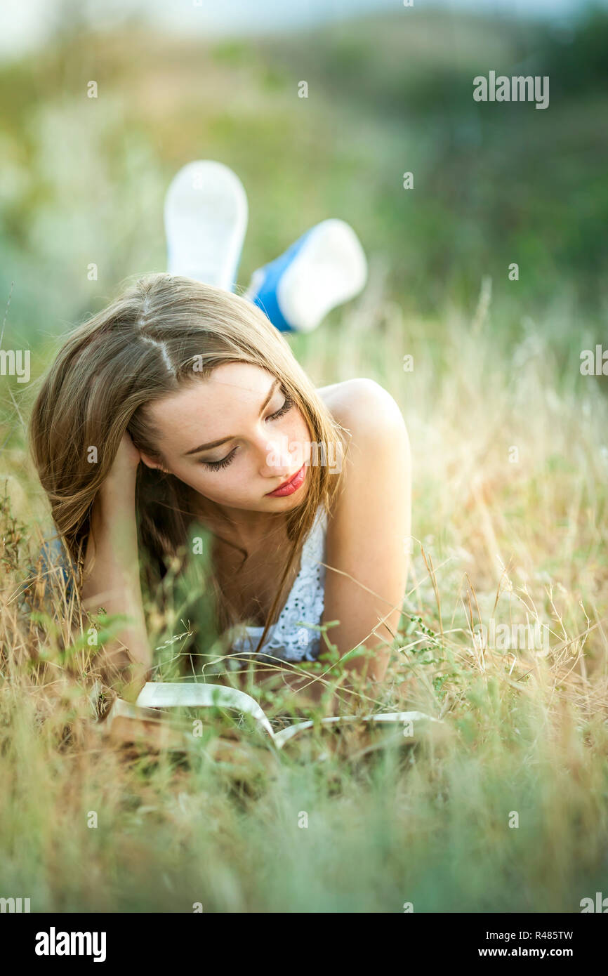 Beautiful girl reading a book on the Nature Stock Photo - Alamy