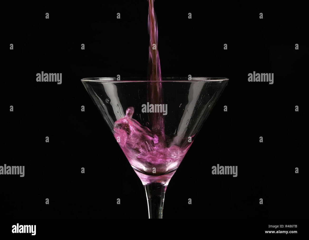 pink cocktail poured into a glass on a dark background Stock Photo - Alamy