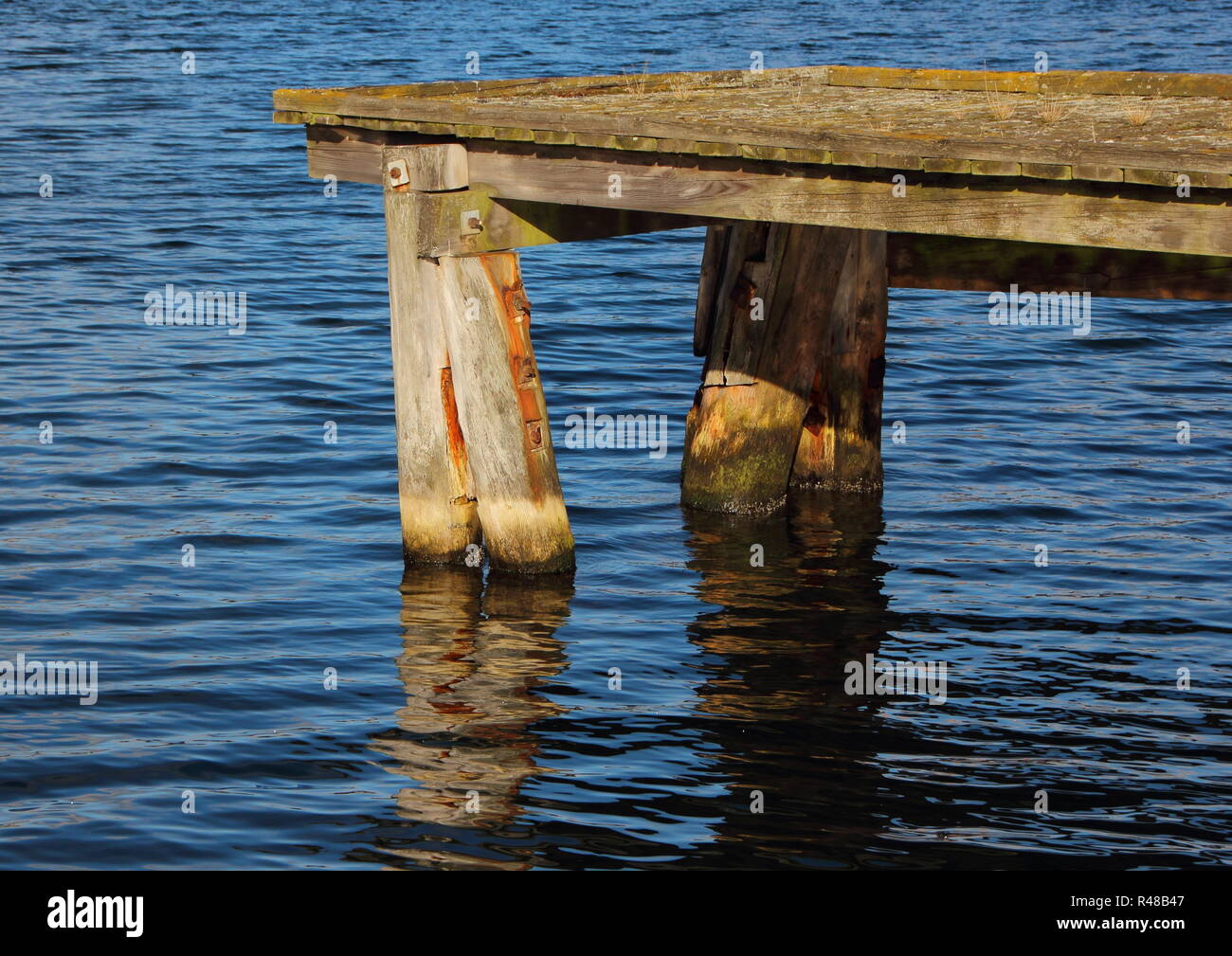 Wooden Pier End with Dark Water Reflection Stock Photo - Alamy
