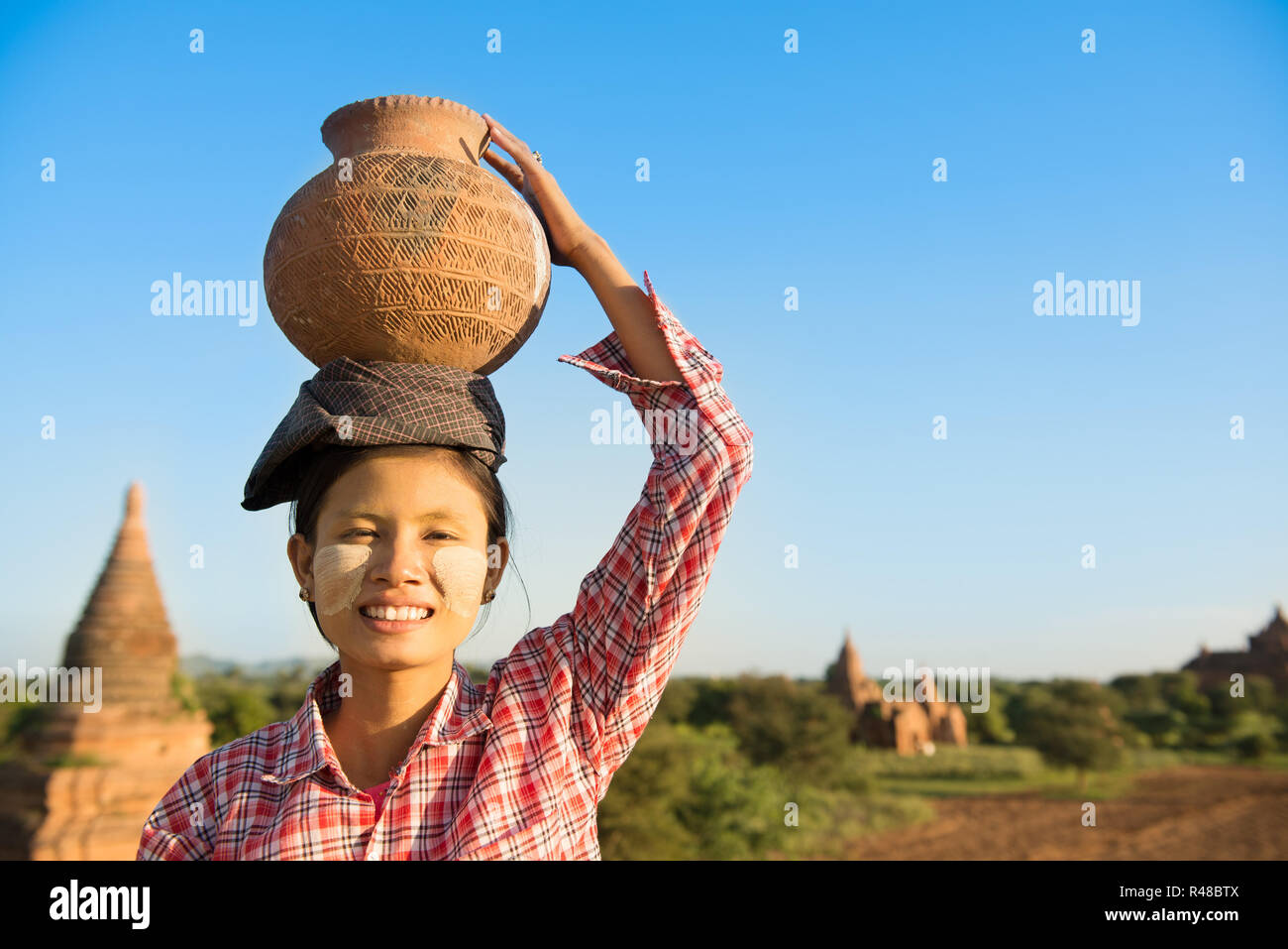 Asian traditional female farmer carrying clay pot on head Stock Photo ...