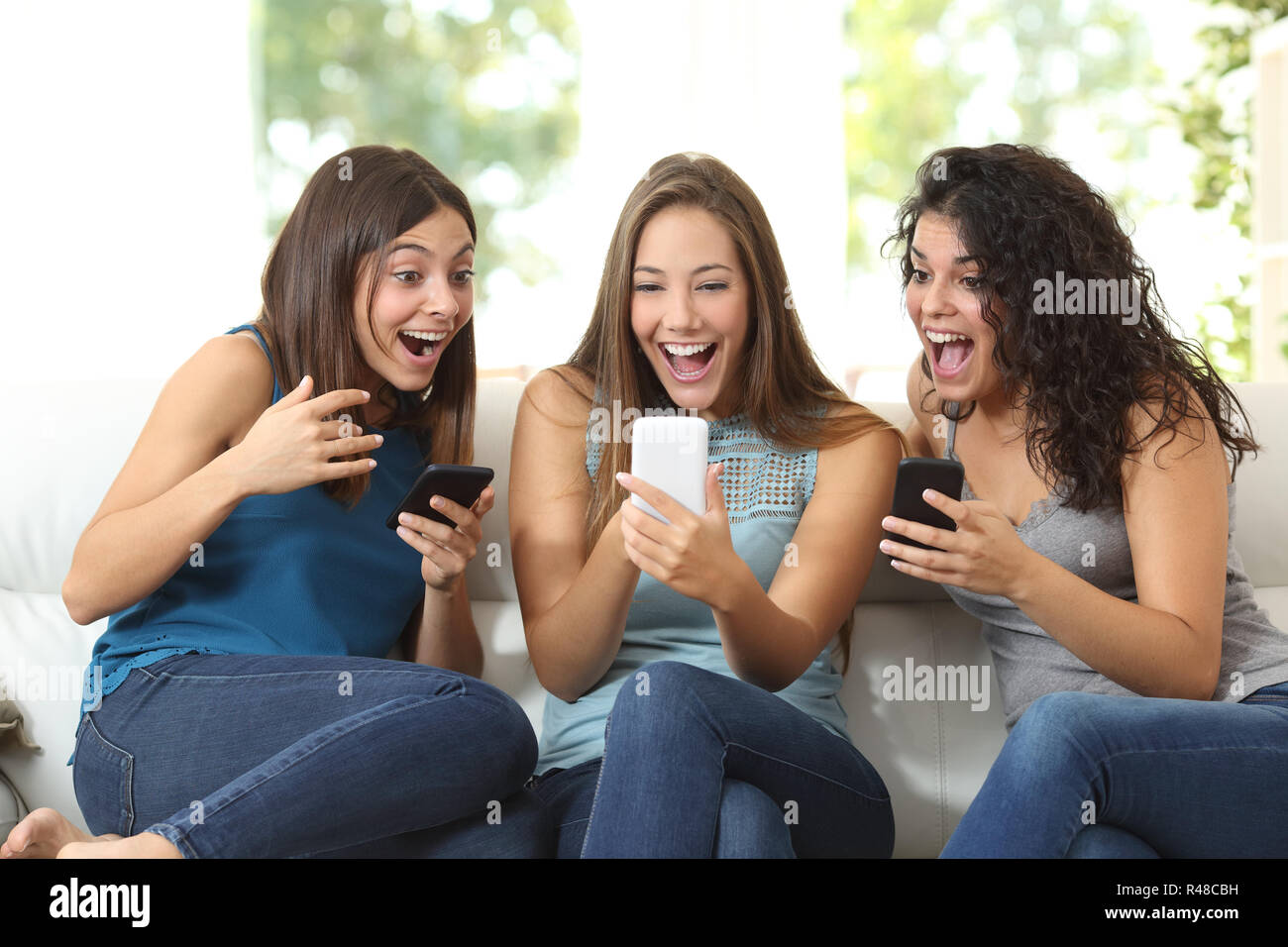 Three girls using a mobile phone hi-res stock photography and images ...