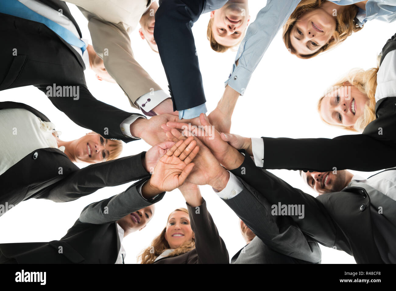 Confident Business Team Stacking Hands While Standing In Huddle Stock ...