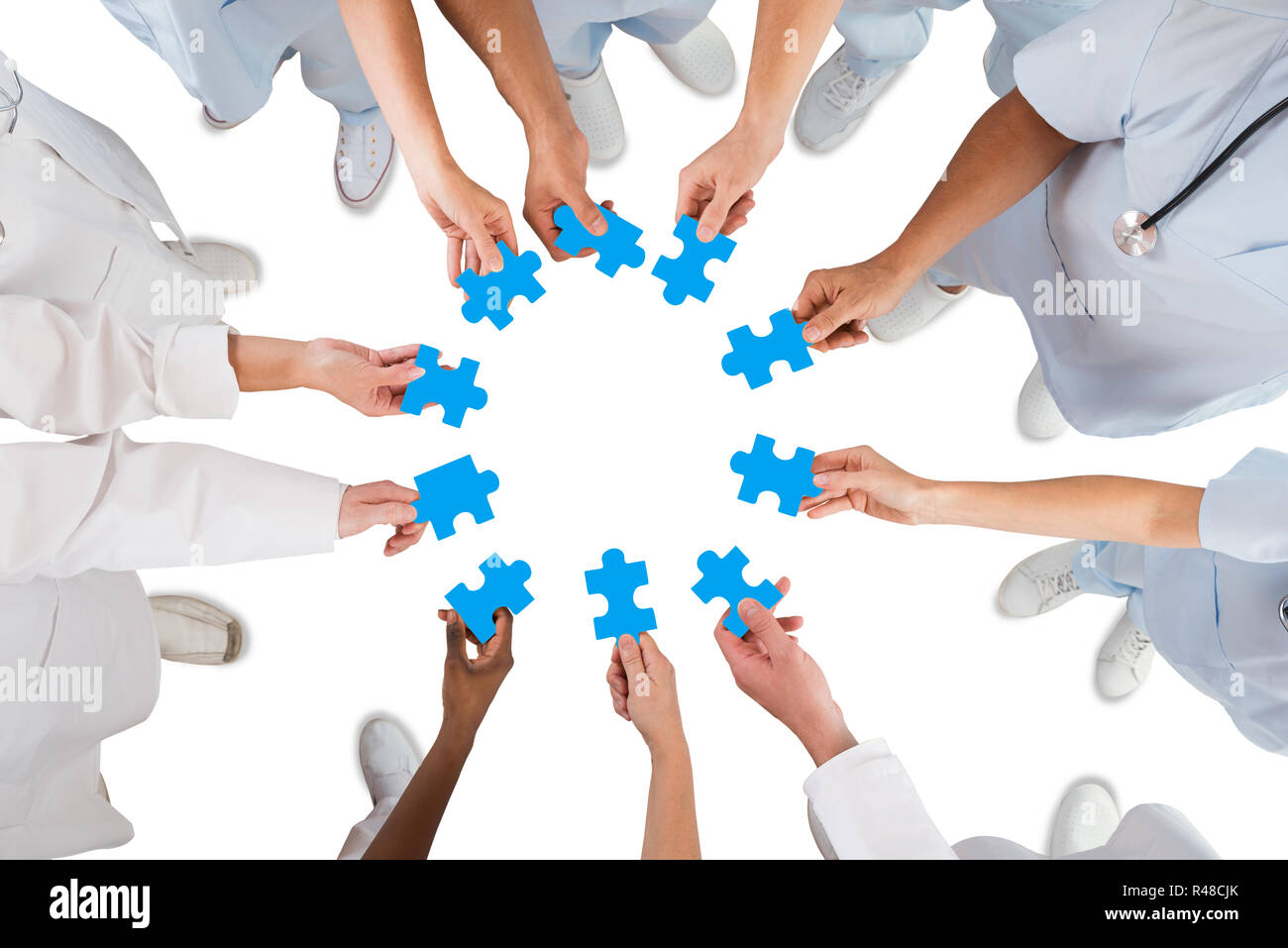 Medical Team Holding Blue Jigsaw Pieces In Huddle Stock Photo - Alamy