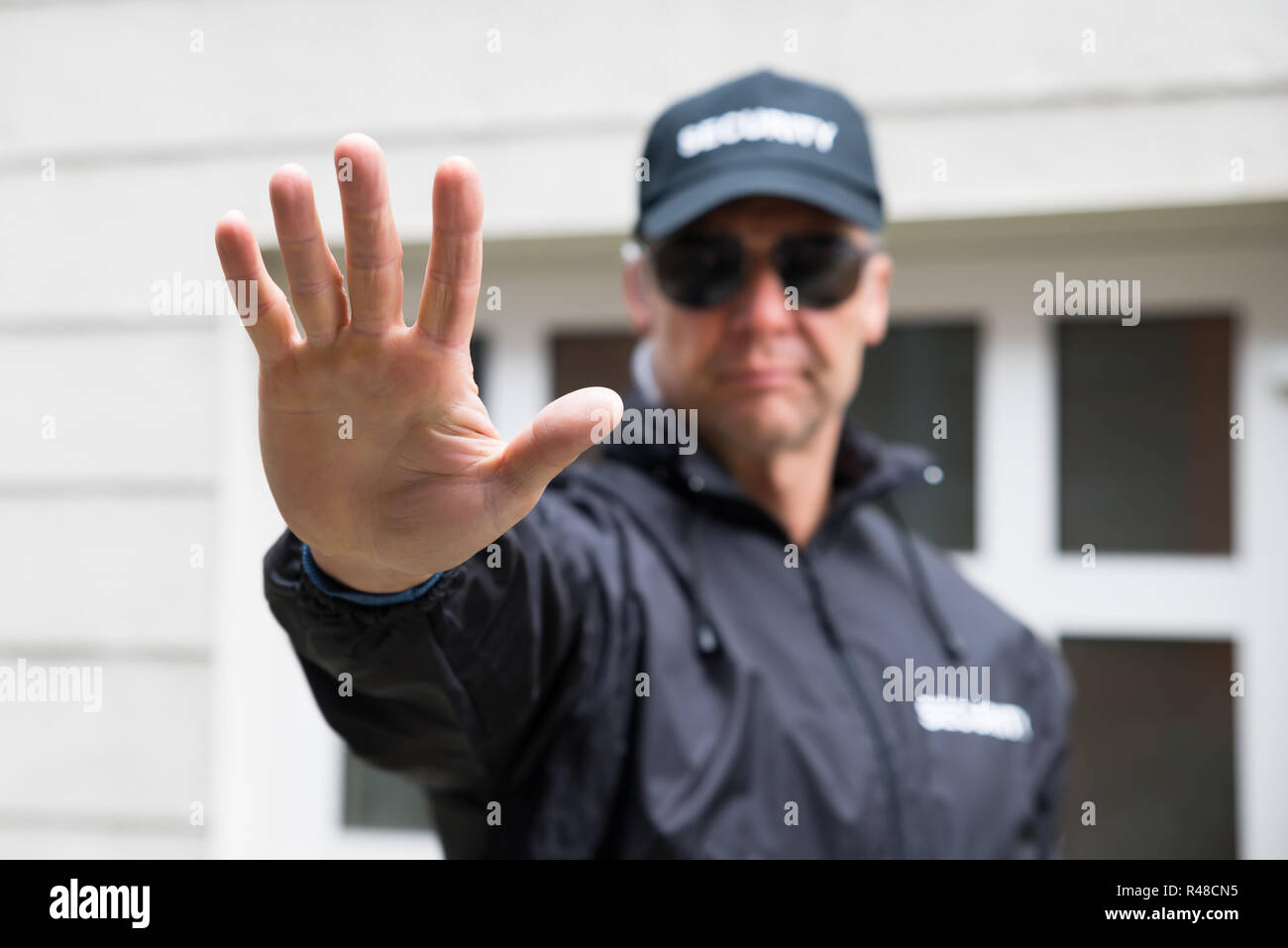 Security Guard Making Stop Gesture Outside Building Stock Photo - Alamy