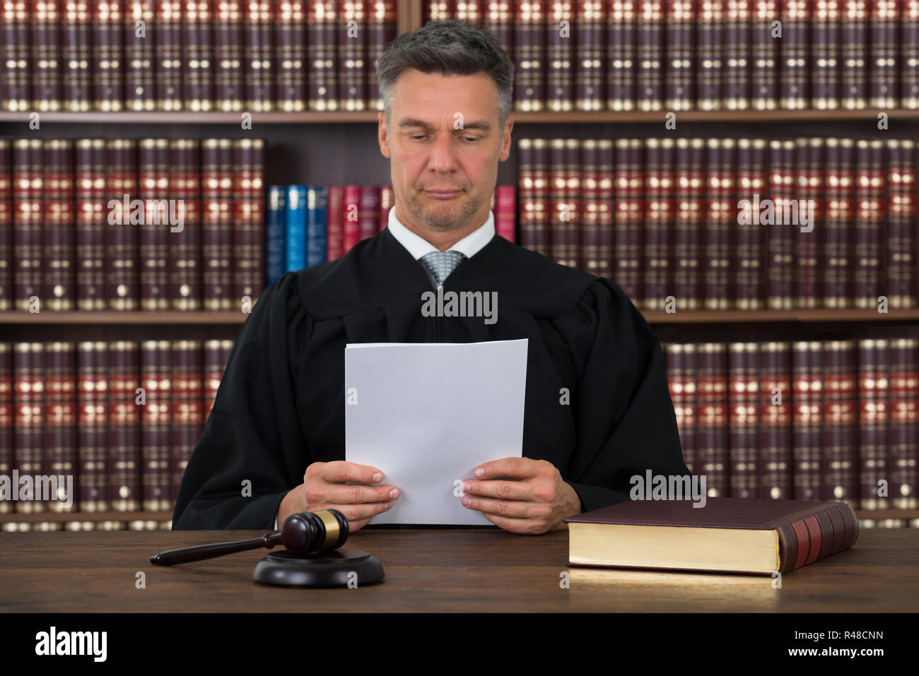 Judge Reading Document At Desk In Courtroom Stock Photo - Alamy