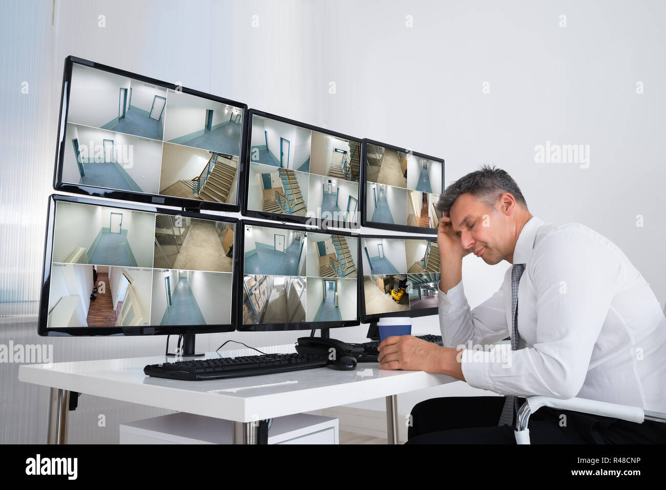 Operator Sleeping While Leaning On Security Monitor's Desk Stock Photo ...
