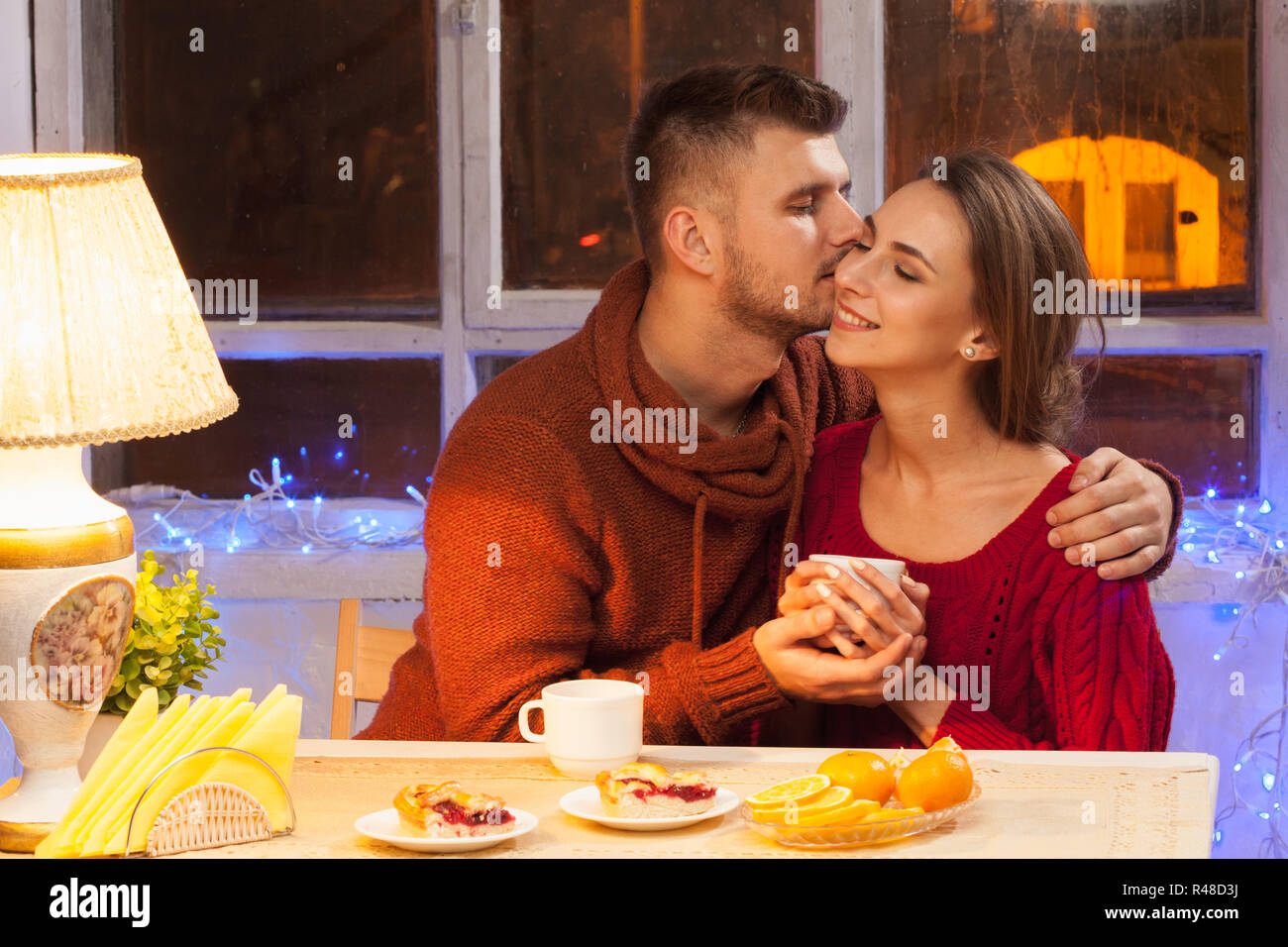 The happy young couple with cups of tea Stock Photo - Alamy