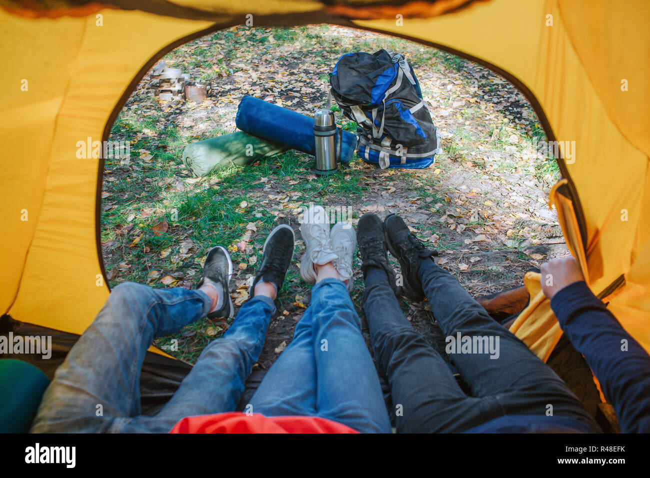 Three bodies lying in tent. Their feet are outside. They wear crosses ...