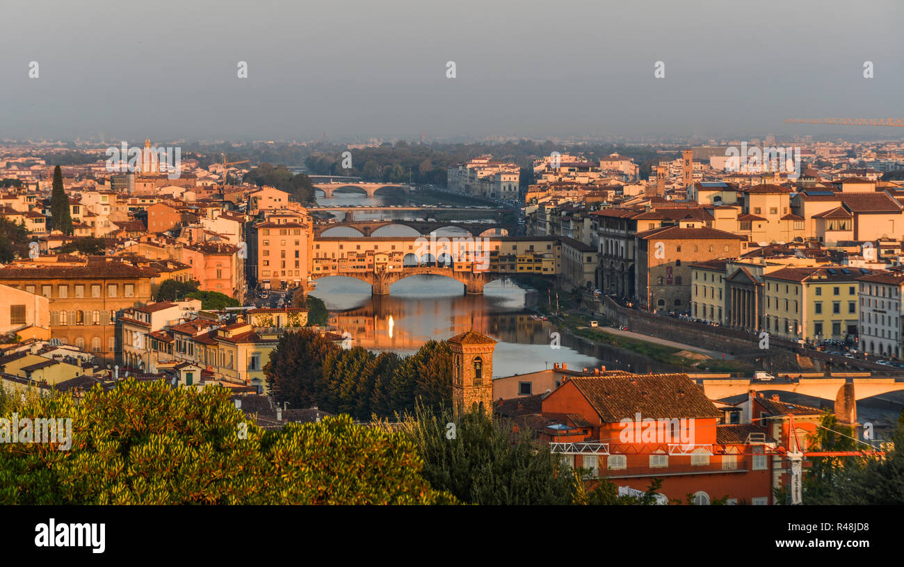 Aerial view of Ponte Vecchio with cityscape at sunrise in Florence ...