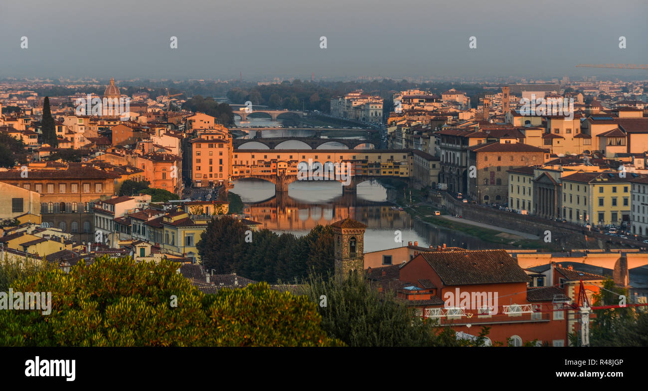 Aerial view of Ponte Vecchio with cityscape at sunrise in Florence ...