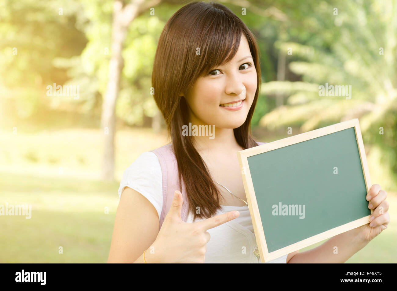 Asian college student pointing at blank chalkboard Stock Photo - Alamy