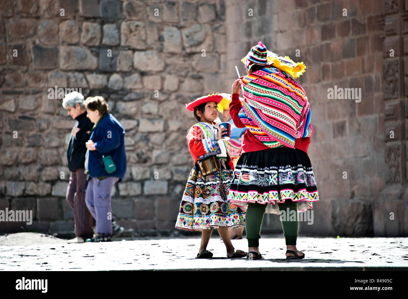 Quechua Indians break from posing with tourists Stock Photo - Alamy