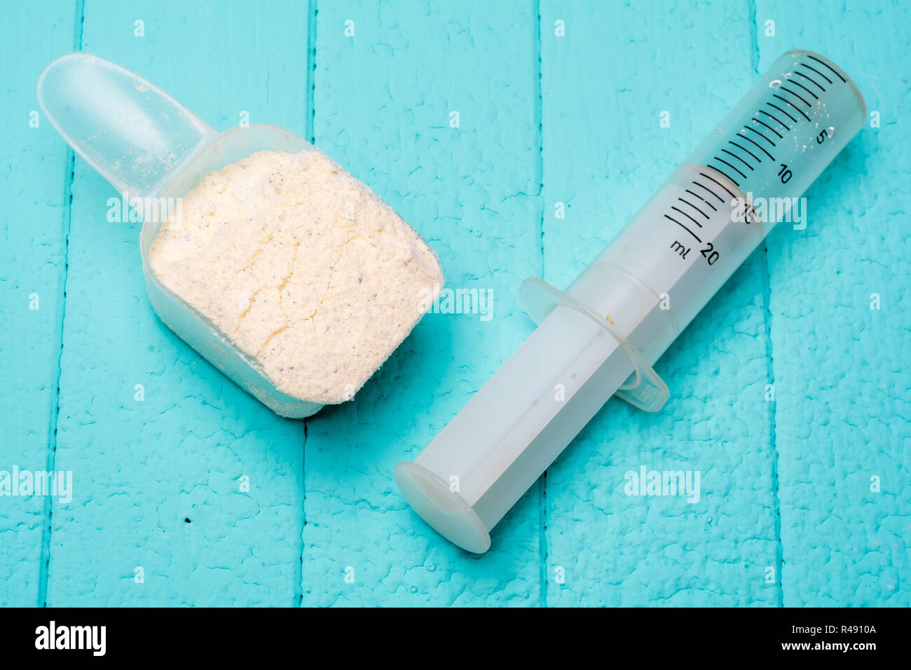 Container of milk whey protein and empty injection. Close-up. Blue ...