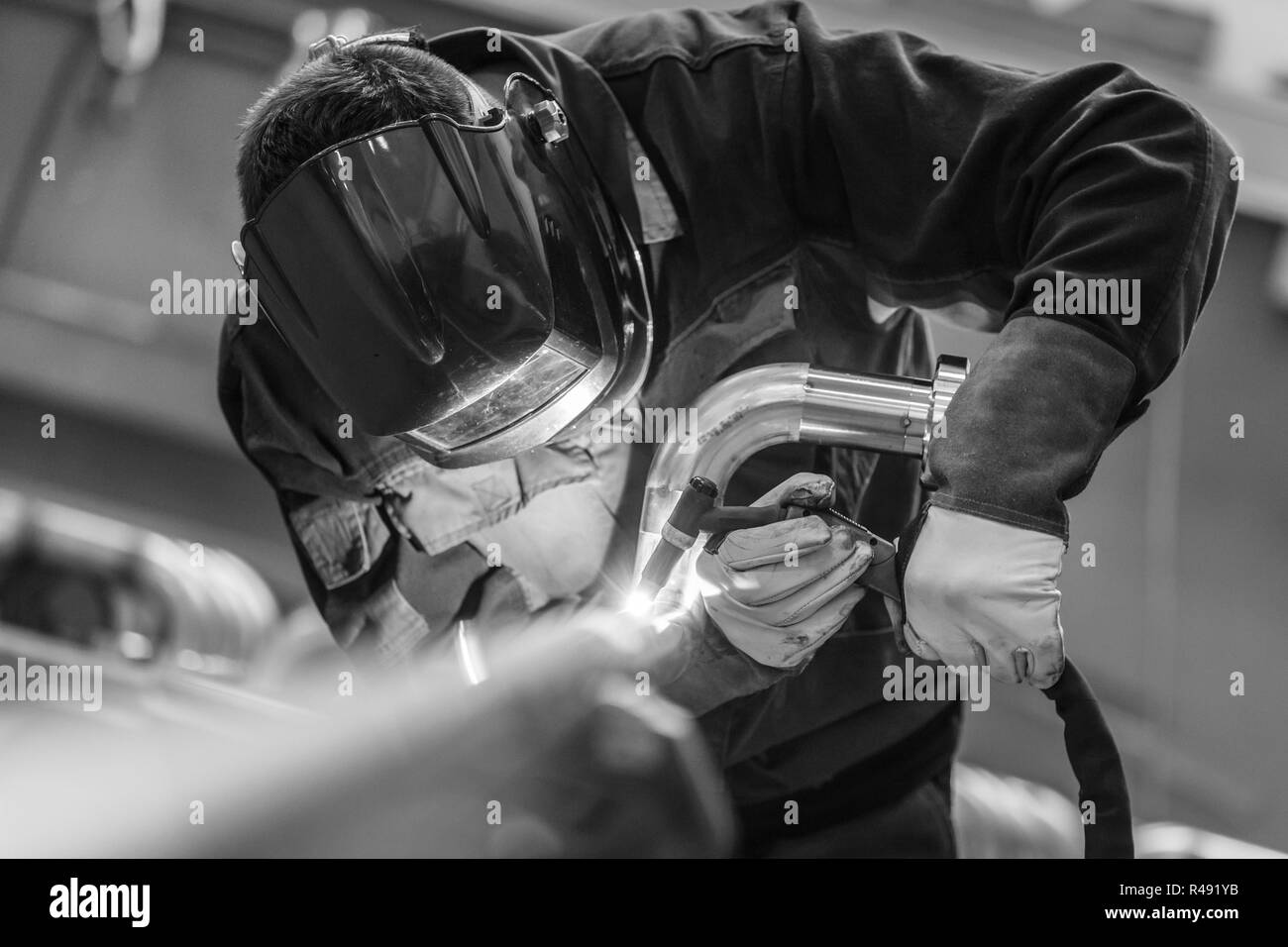 Industrial worker welding in metal factory Stock Photo - Alamy
